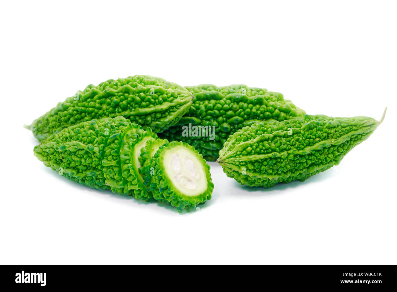 Courge amère pile et pièce sur fond blanc. les légumes nourrissent le ...