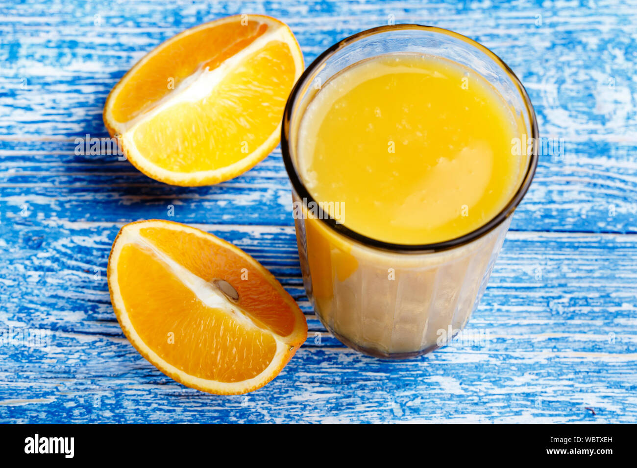 Couper l'orange frais juteux et un verre de jus de fruit frais sur un ...