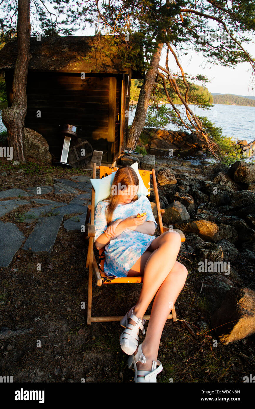 Jeune femme assise dans une chaise longue Banque de photographies et d’images à haute résolution ...