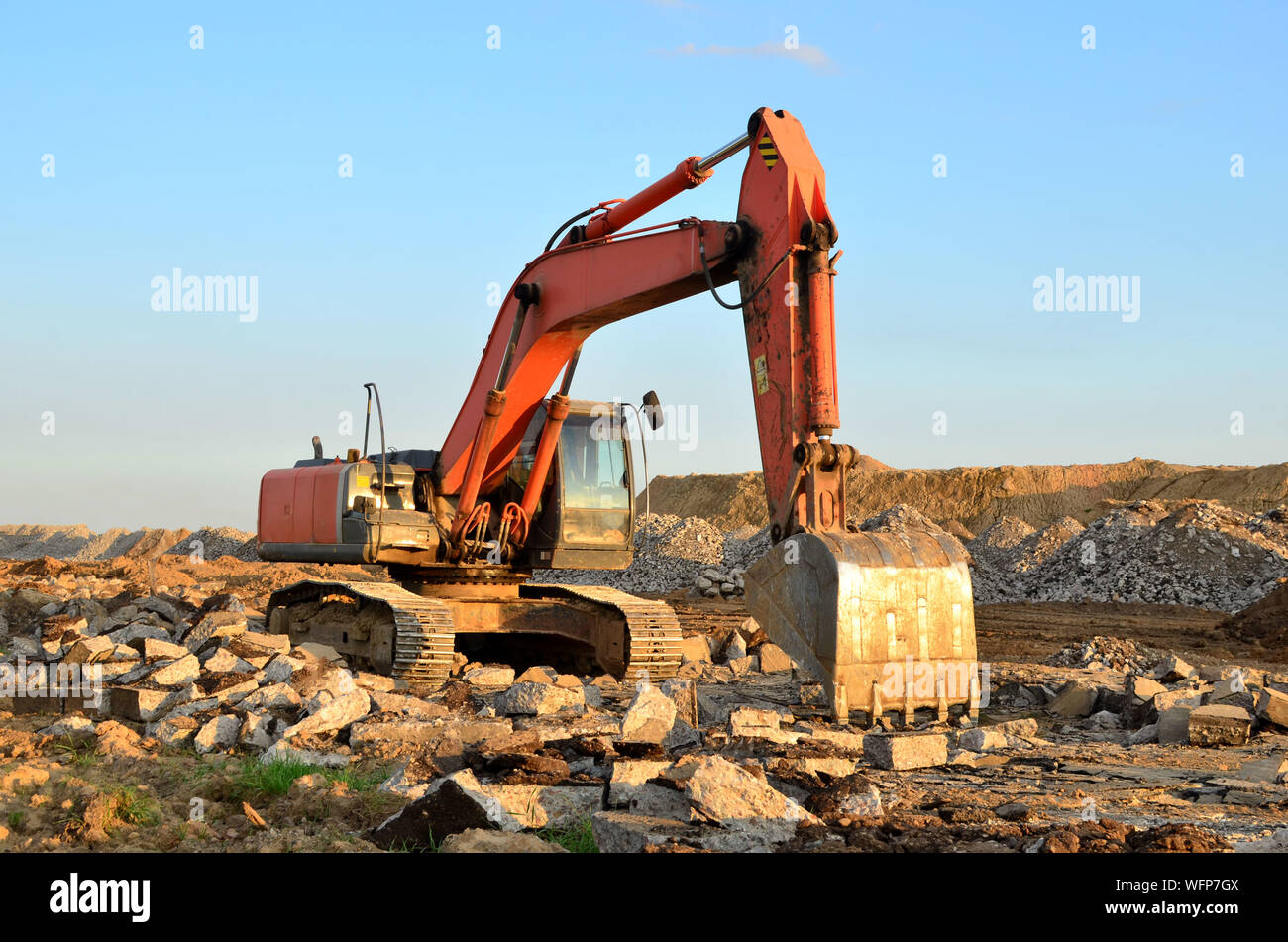 Un lourd travail d'excavateur dans une carrière de granit à décharge ...
