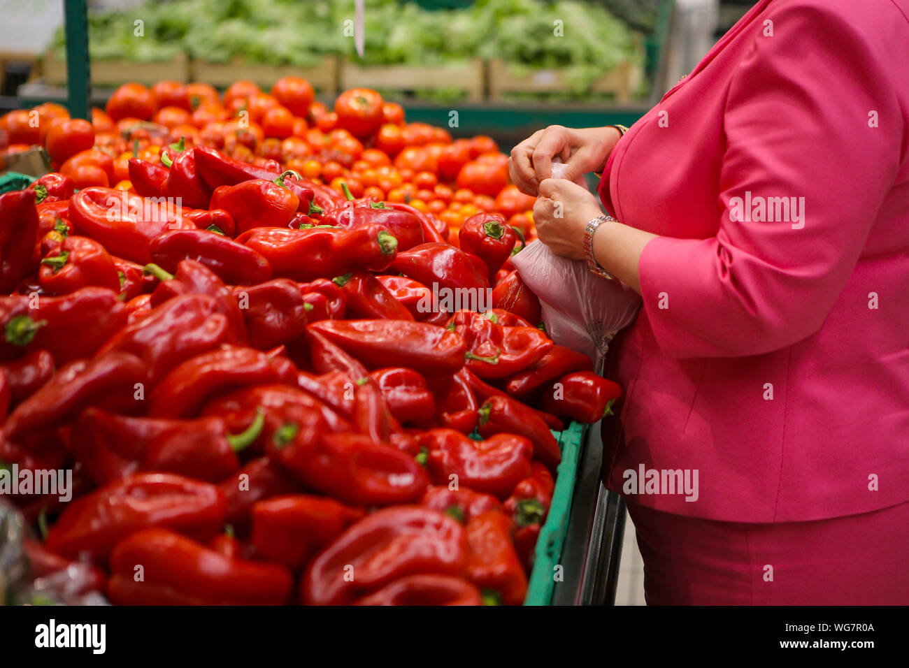 Femme choisissant poivrons rouges doux sur l'allée des fruits et ...