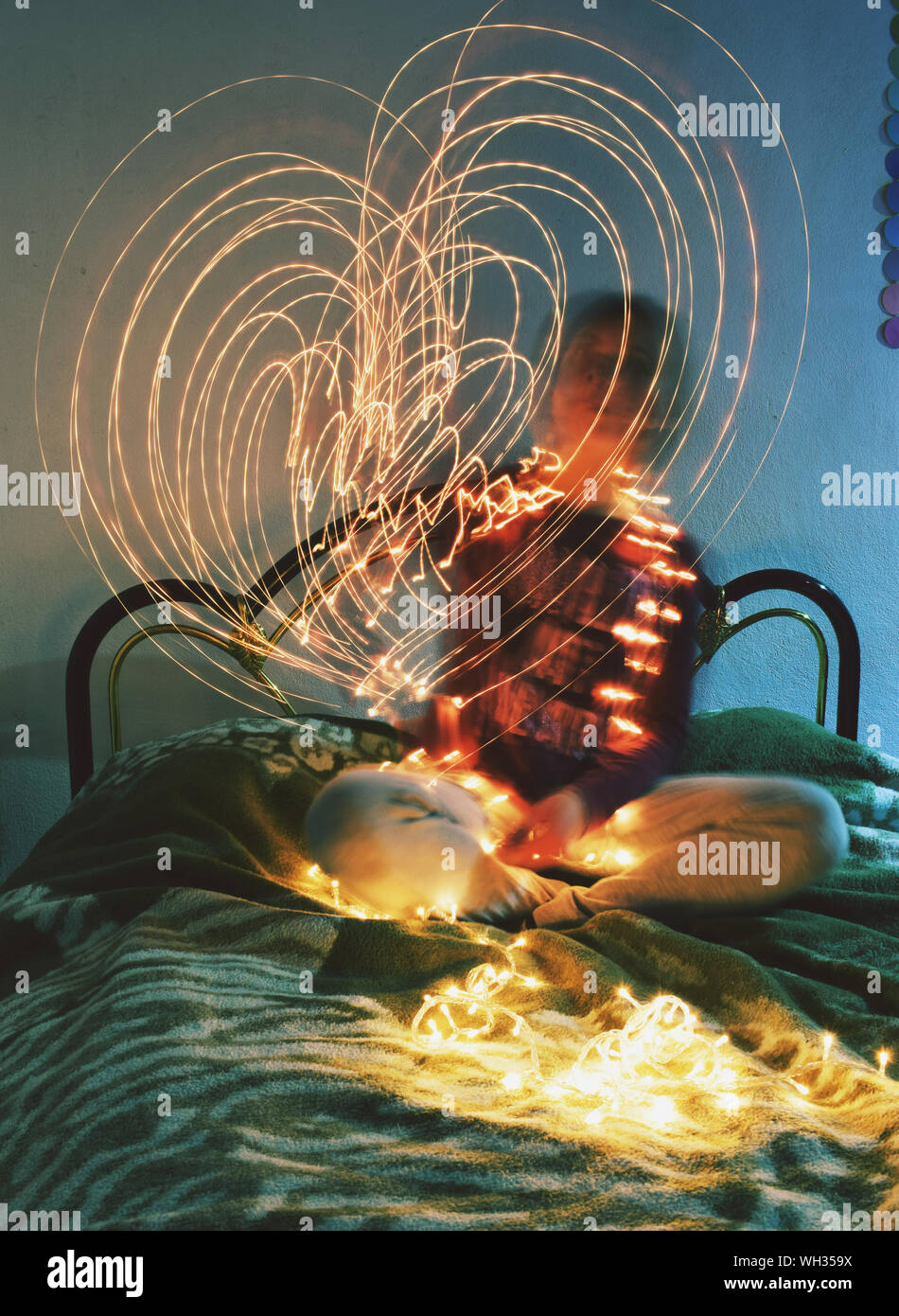 Jeune Femme Assise En Tailleur Sur Le Lit Banque De Photographies Et D