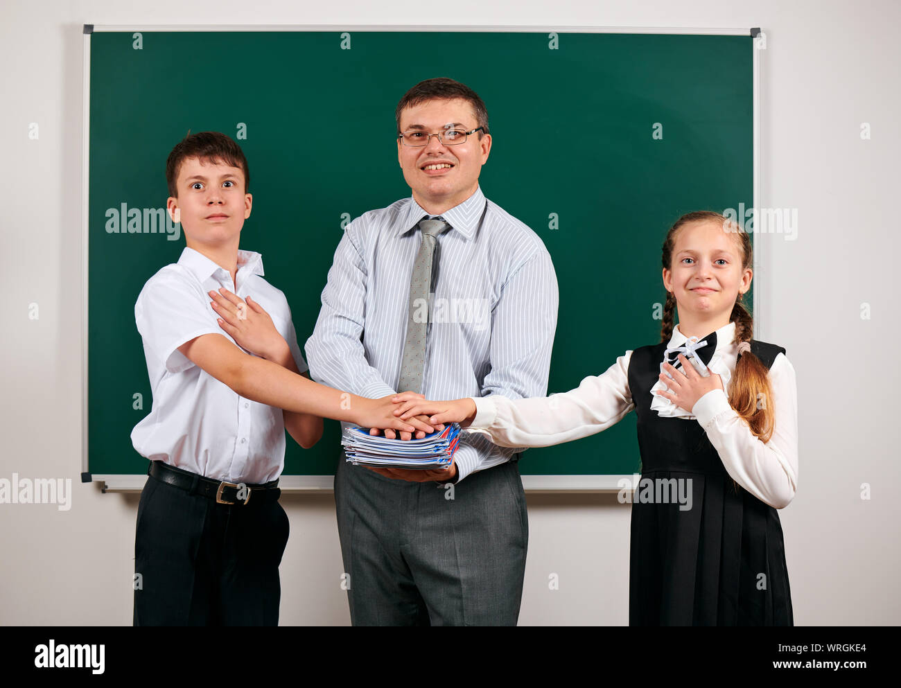 Portrait d'un professeur et élève, posing at blackboard background ...