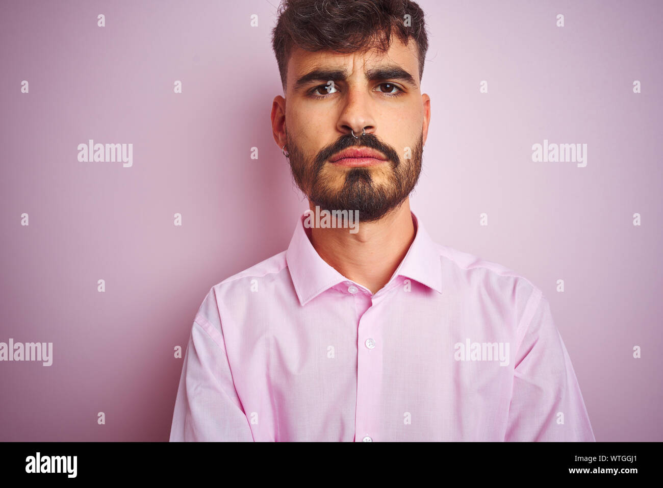 Jeune homme en chemise sur le port permanent isolé sur fond rose ...