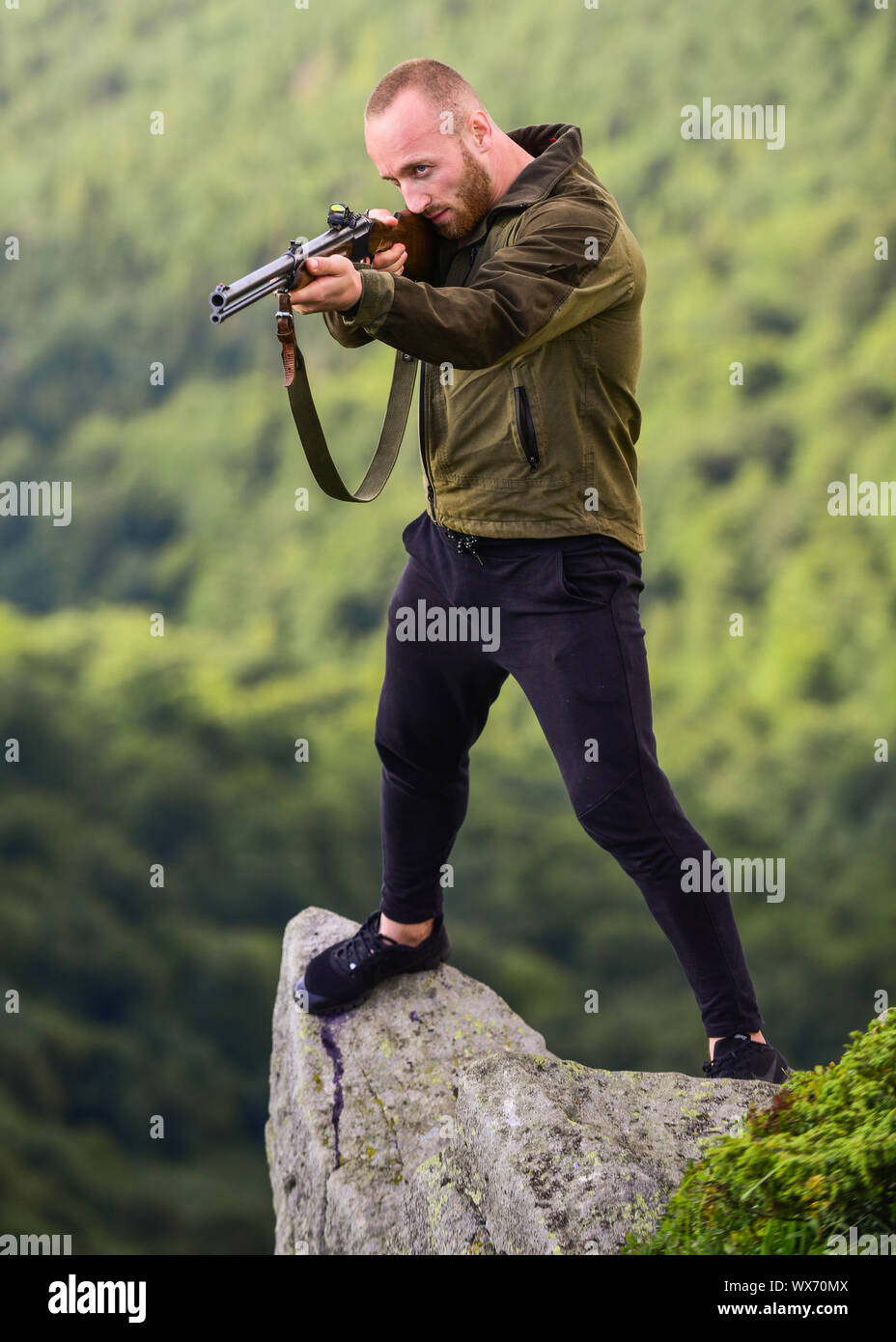 Concept de braconnage. Braconnier position sur bord de la falaise ...