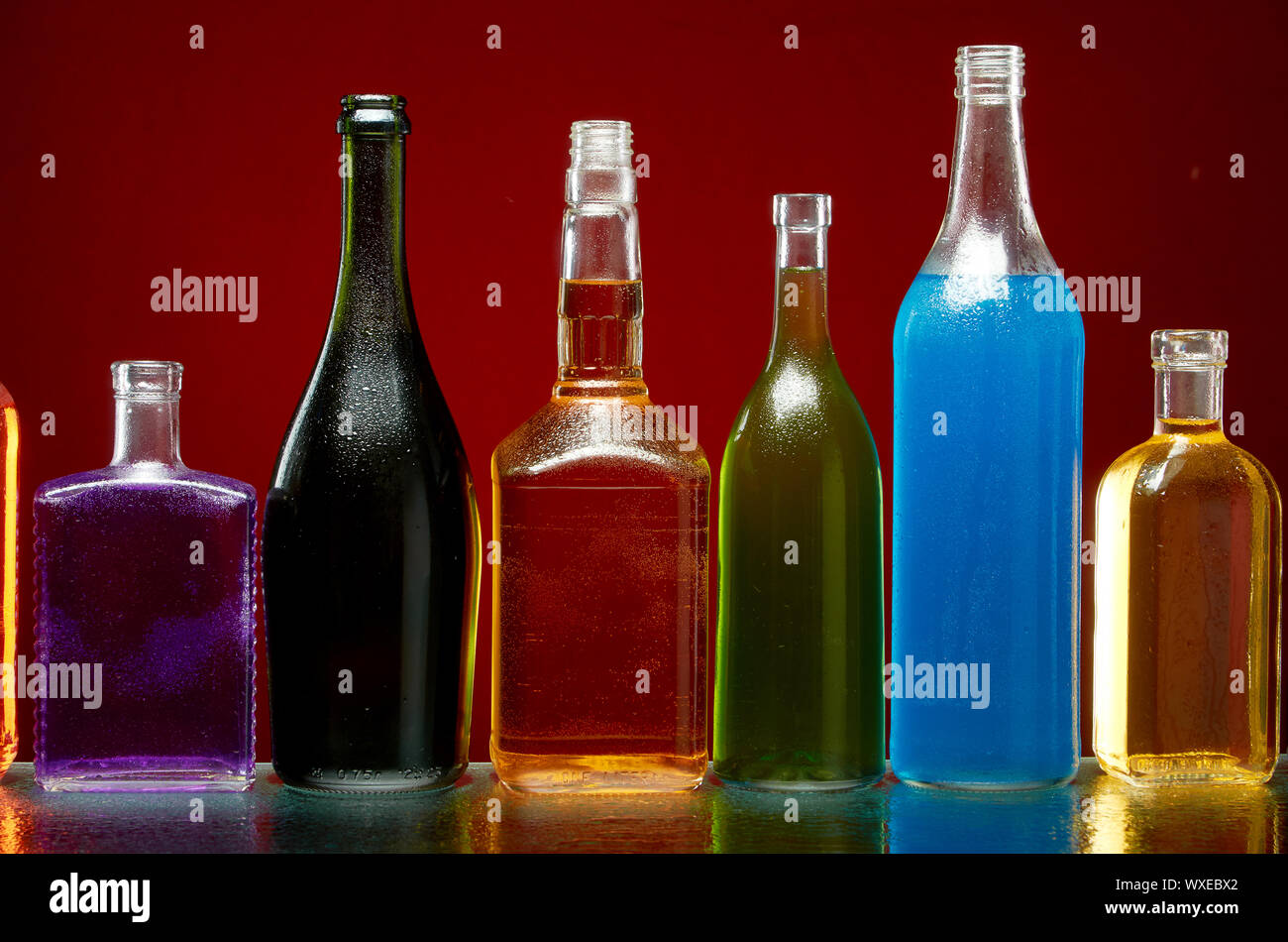 Différentes boissons alcoolisées en bouteilles transparentes sur fond ...
