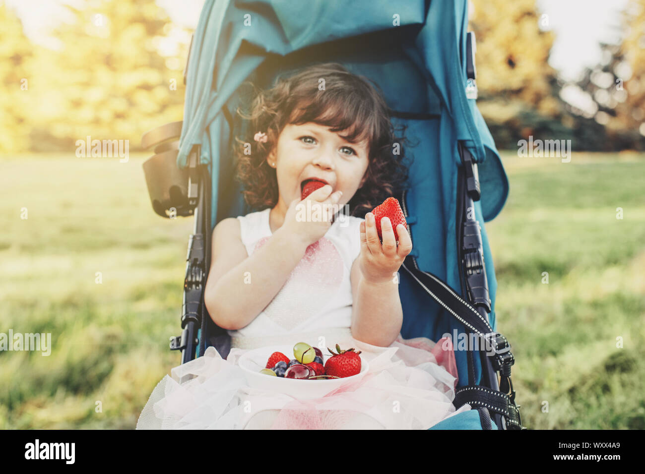 Adorable baby girl eating raspberry Banque de photographies et d’images ...