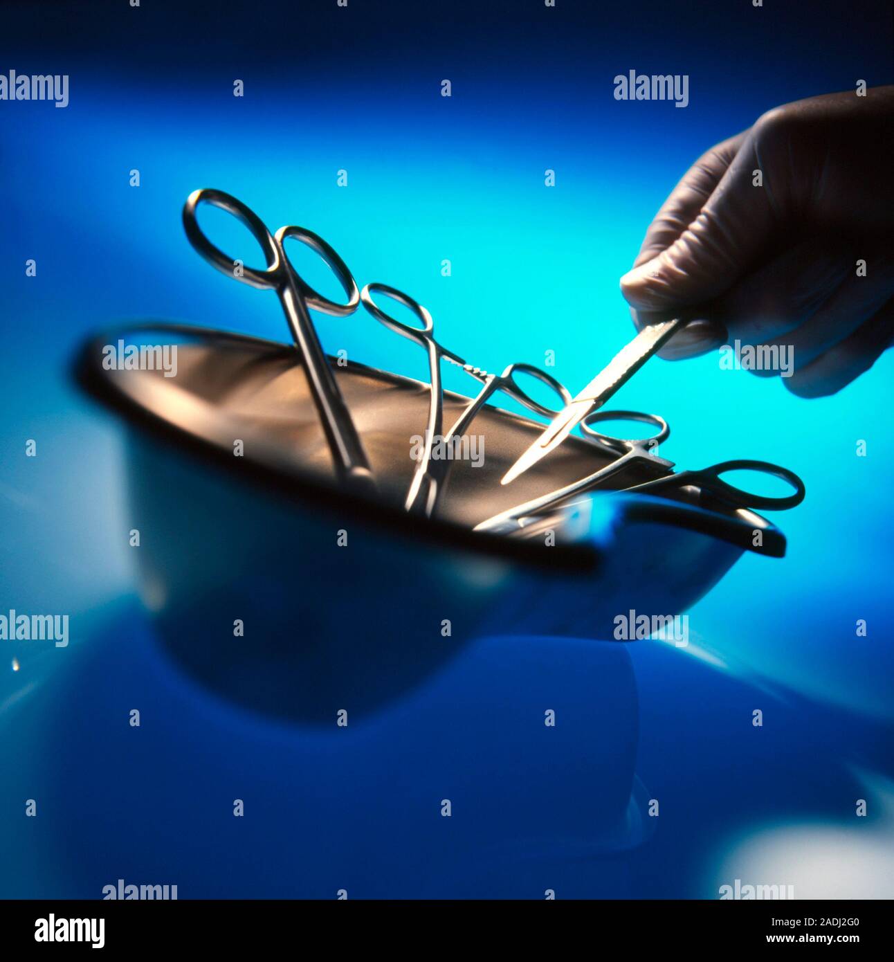 Apparecchiatura chirurgica nel recipiente. La mano guantata luoghi un ...