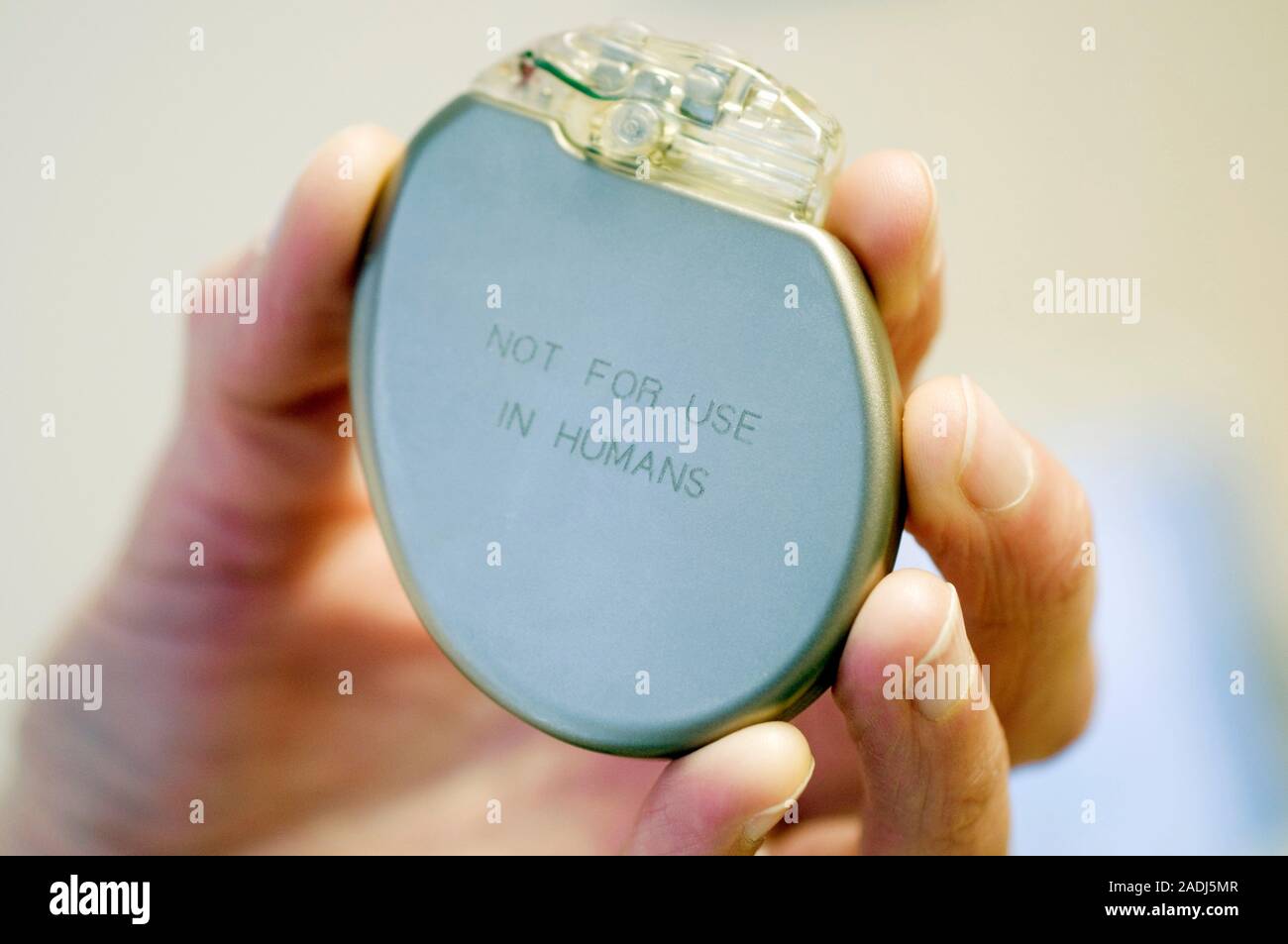 Pacemaker cardiaco demonstrator tenuto in una mano. I pacemaker sono ...