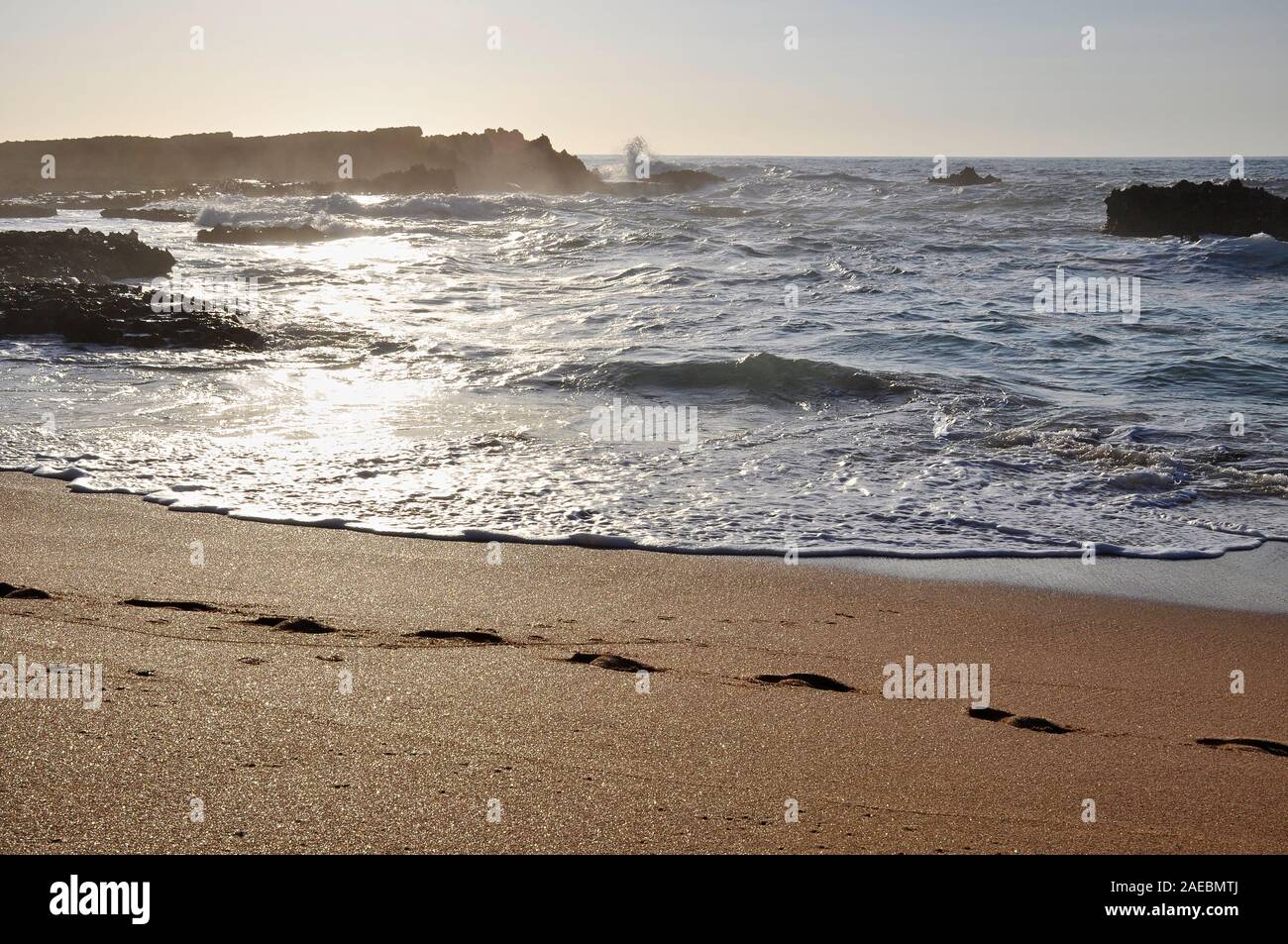 Riva del mare e del litorale con ruvida mare atlantico e impronte umane ...