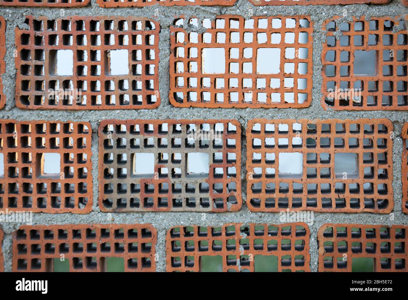 Muro costruito di mattoni forati. I fori sono intonacati con quadrato e ...