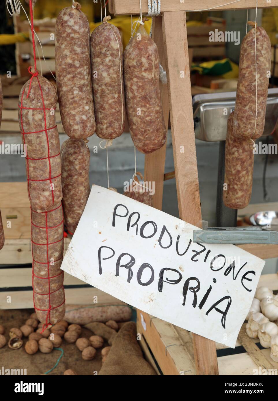 Molti salami appesi in vendita nel negozio italiano e il testo che ...