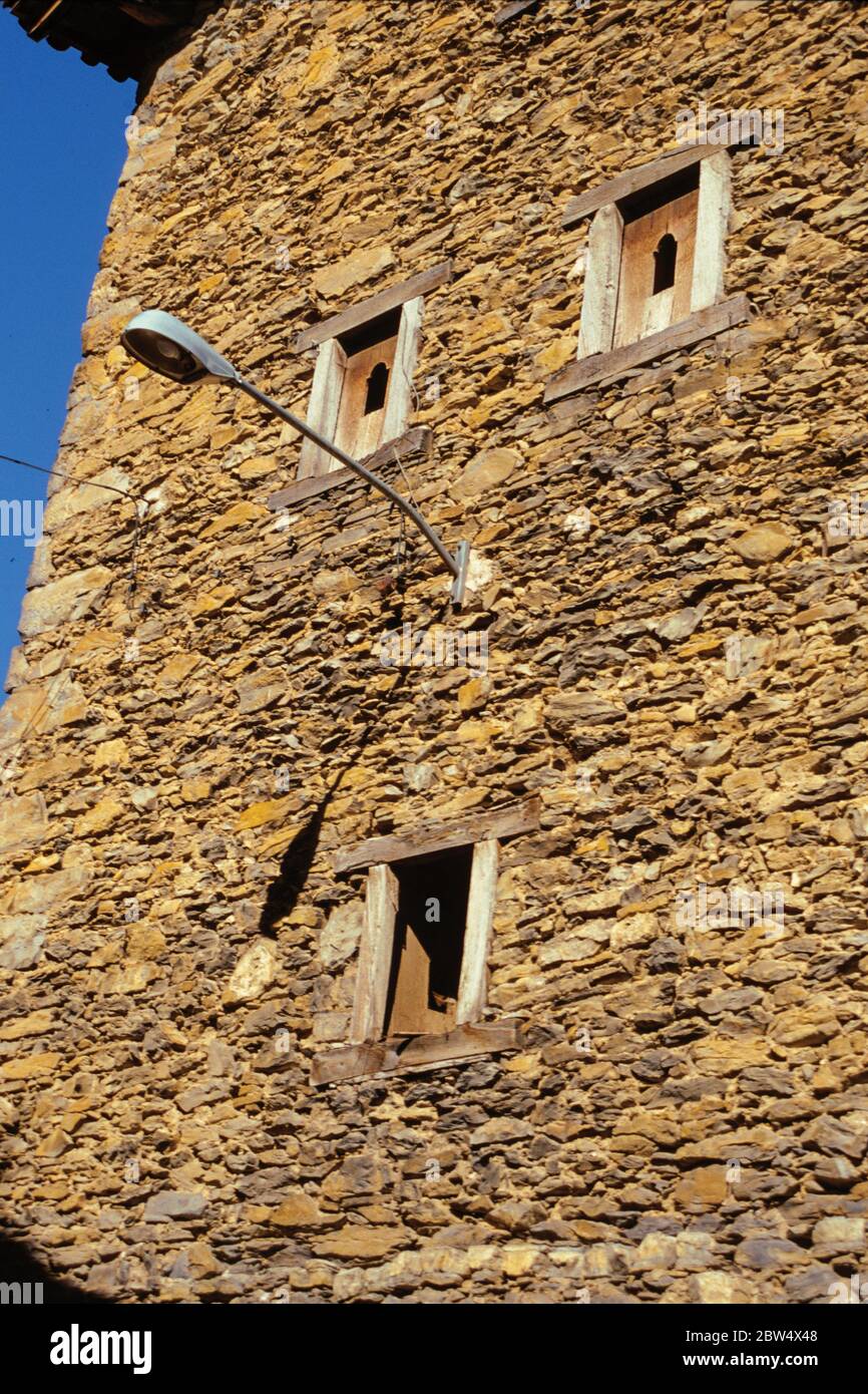 Facciata in pietra di una vecchia casa con finestre e lampada attaccate ...