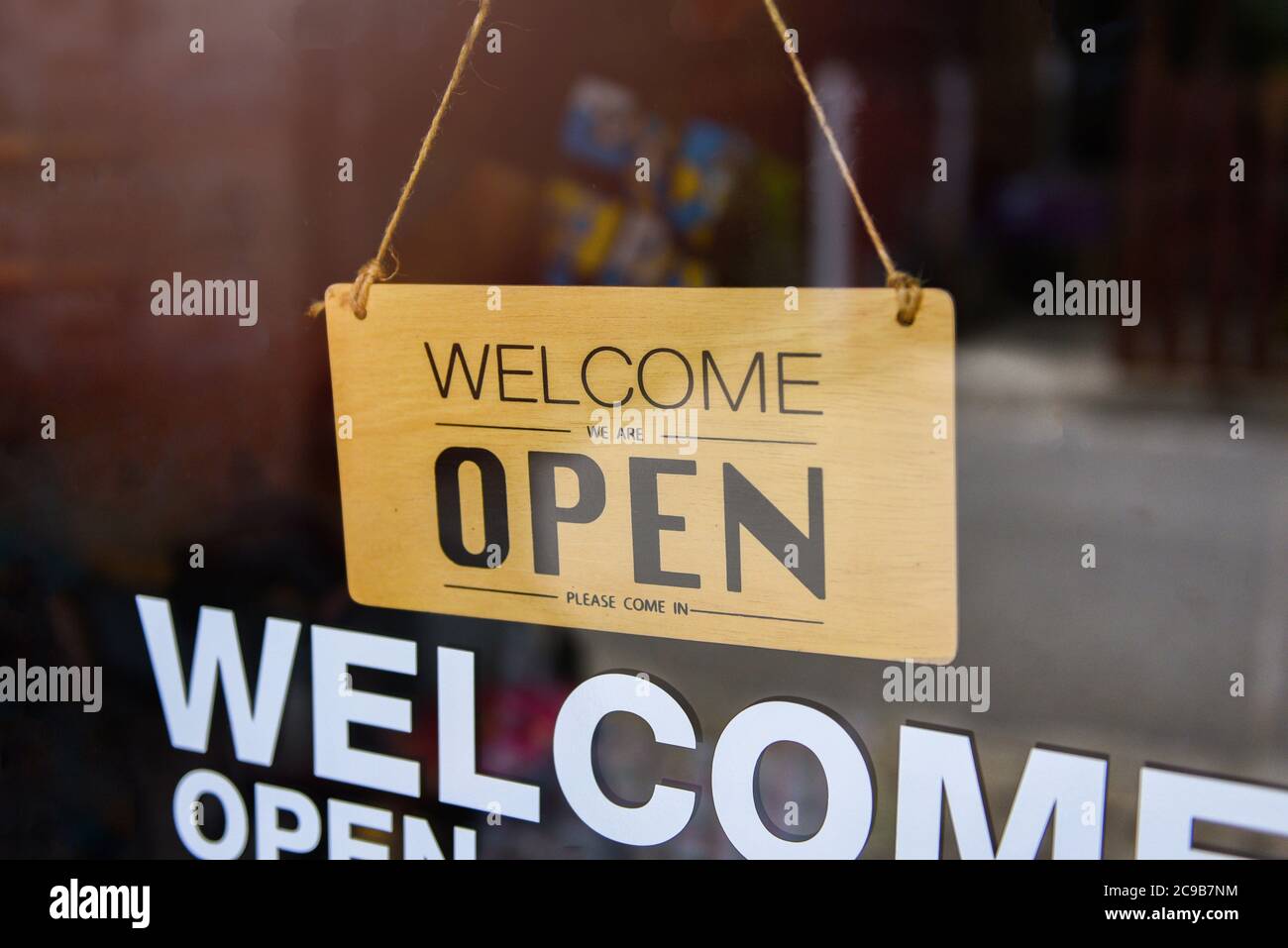 Cartello aperto/cartello di benvenuto appeso alla porta di vetro del ...