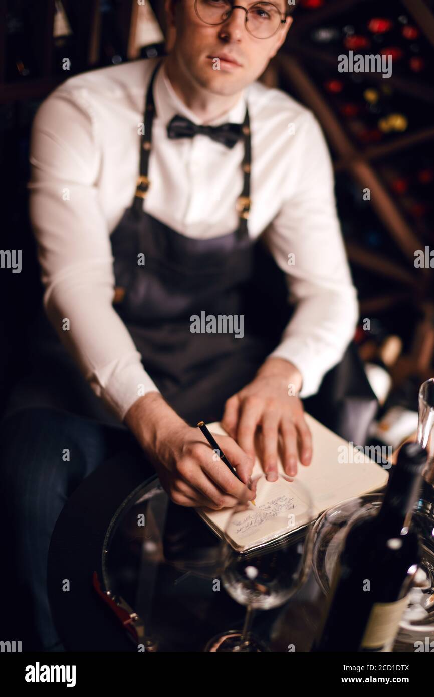 Cavista maschile professionista esamina le bottiglie con vino e fare ...