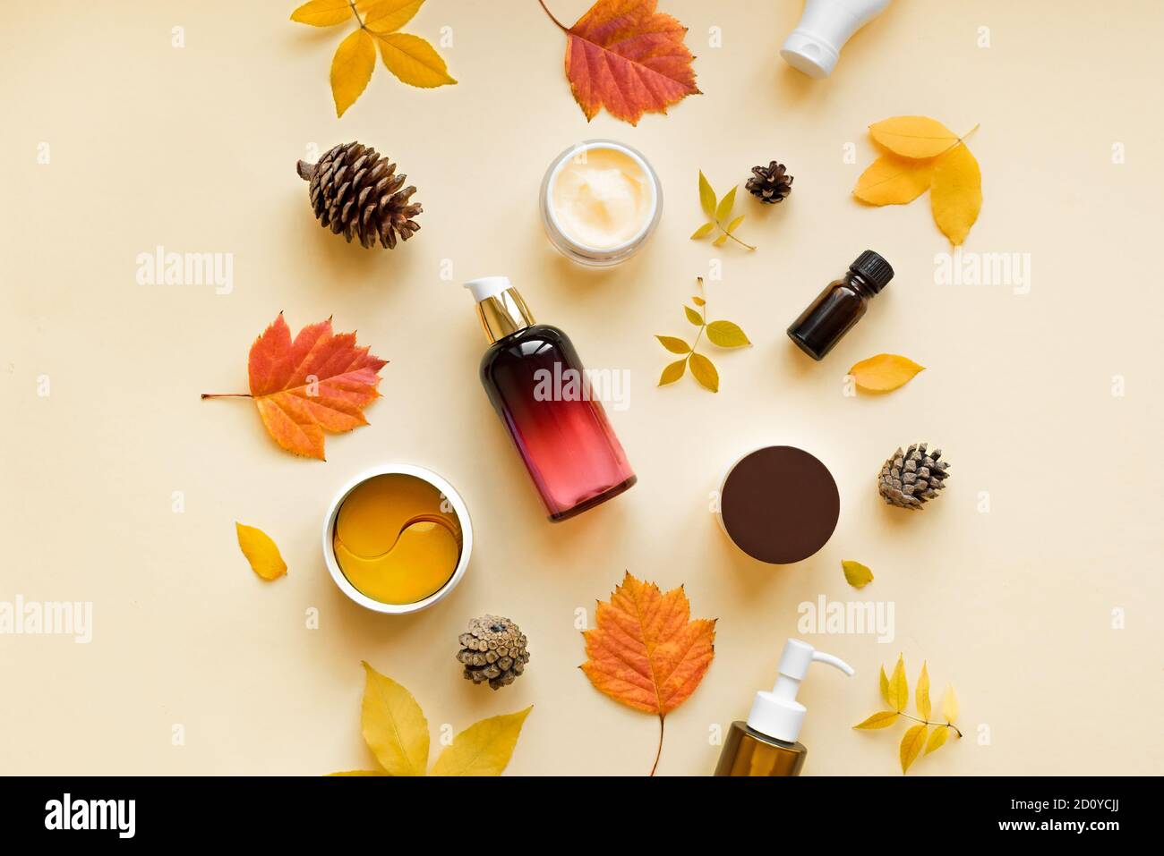 Prodotti autunnali Skin Care e foglie autunnali su sfondo giallo, posa ...