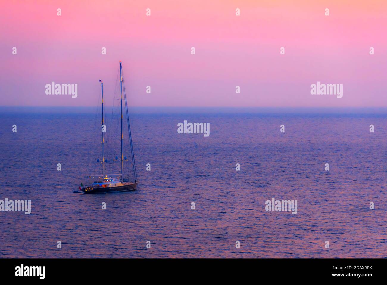 barca a vela a due alberi che naviga verso l'orizzonte in uno ...