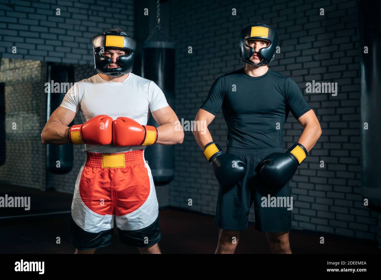 due muscle boxer o combattenti in guanti da boxe e casco in palestra ...