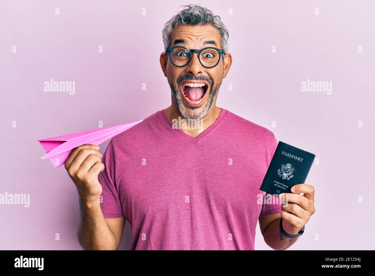 Uomo di mezza età con capelli grigi che tiene l'aereo di carta e il ...