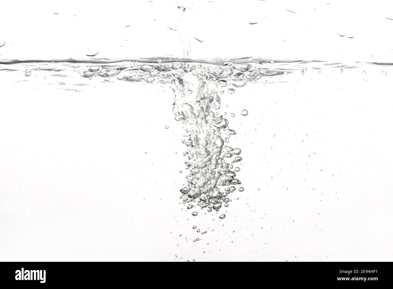 Acqua versata nel serbatoio, bolle e schizzi visibili su sfondo bianco ...