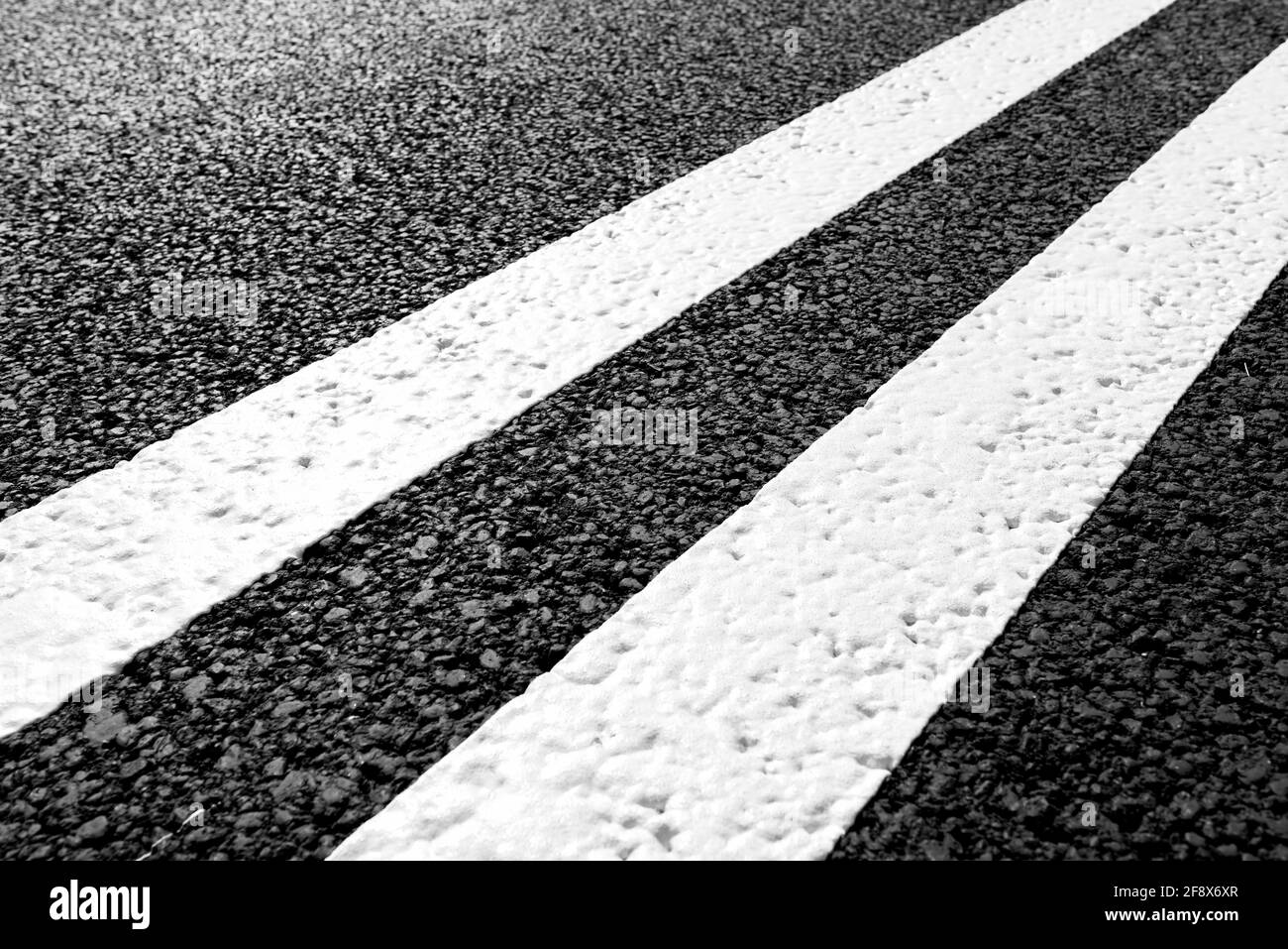 Strada asfaltata con linee di marcatura strisce bianche Foto stock - Alamy