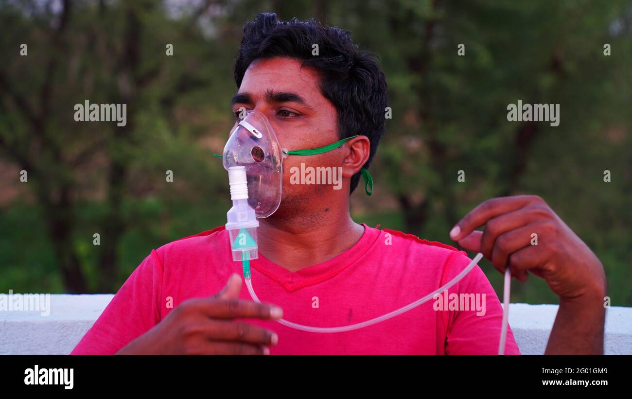 Giovane uomo inalare con maschera di ossigeno sul viso durante la ...