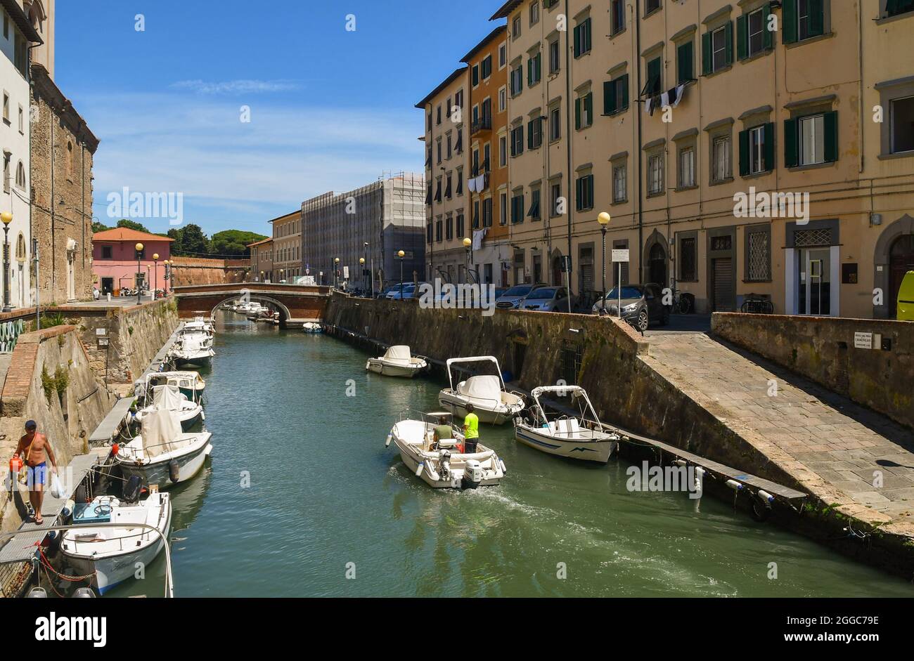 Una piccola barca che naviga su un canale del quartiere Venezia Nuova ...