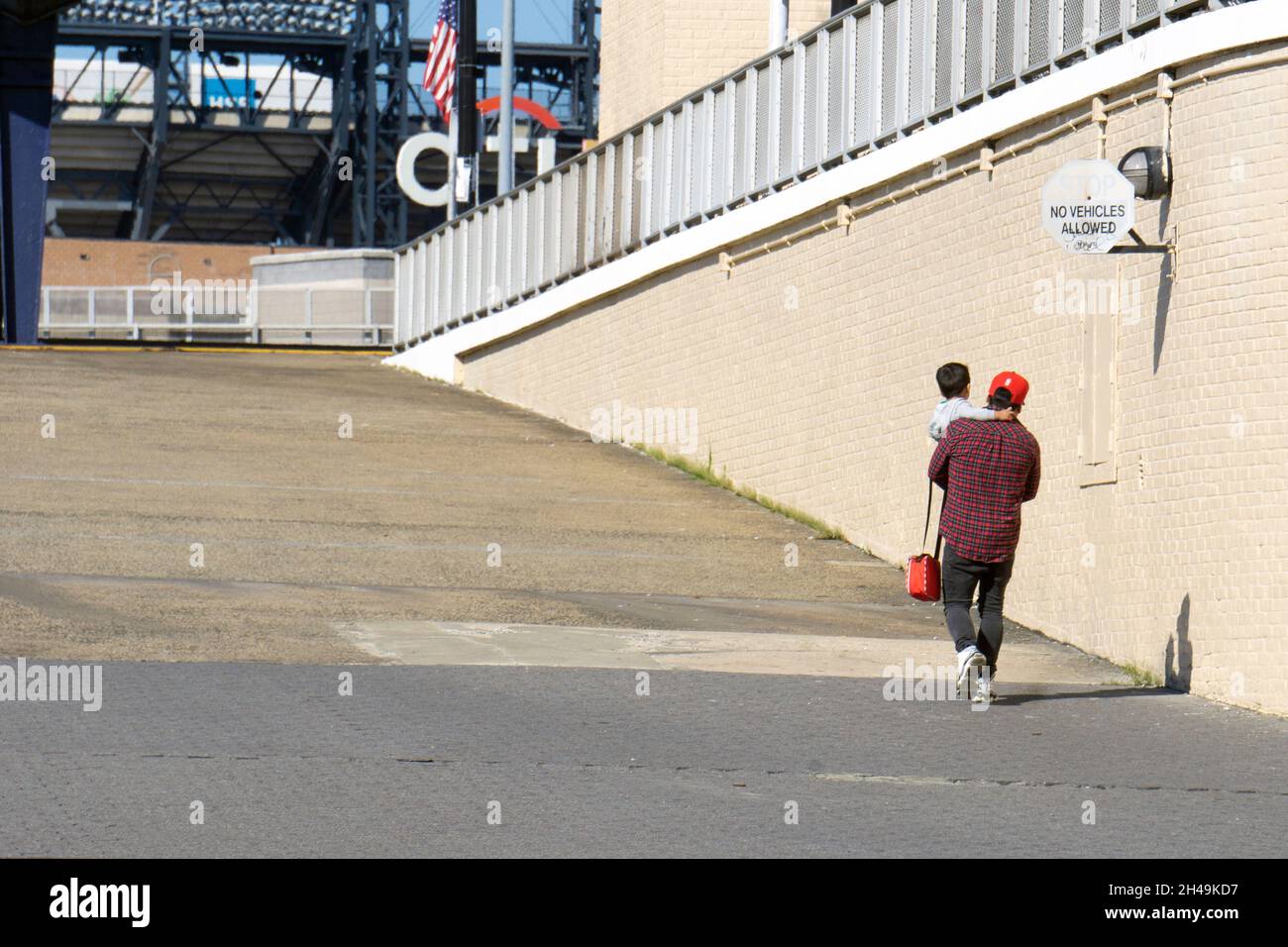 Un padre che porta suo figlio cammina su una rampa che li porta da ...