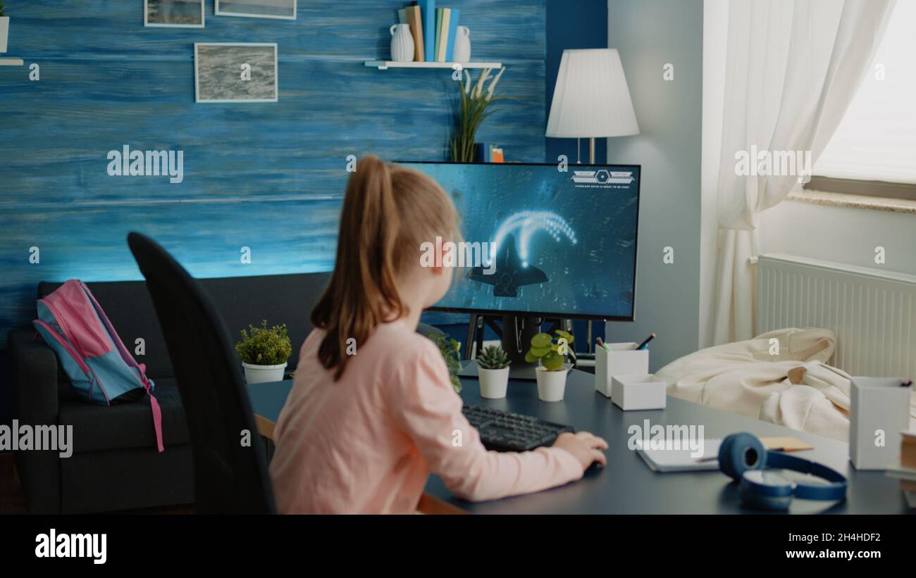 Ragazza giovane che gioca a sparare video giochi sul computer alla ...