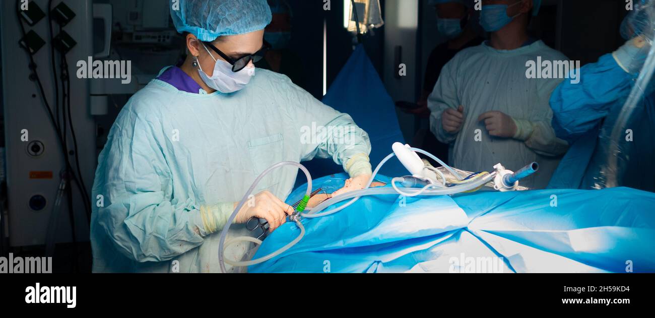 Chirurgo donna con occhiali 3D sutura la pelle del paziente dopo l ...
