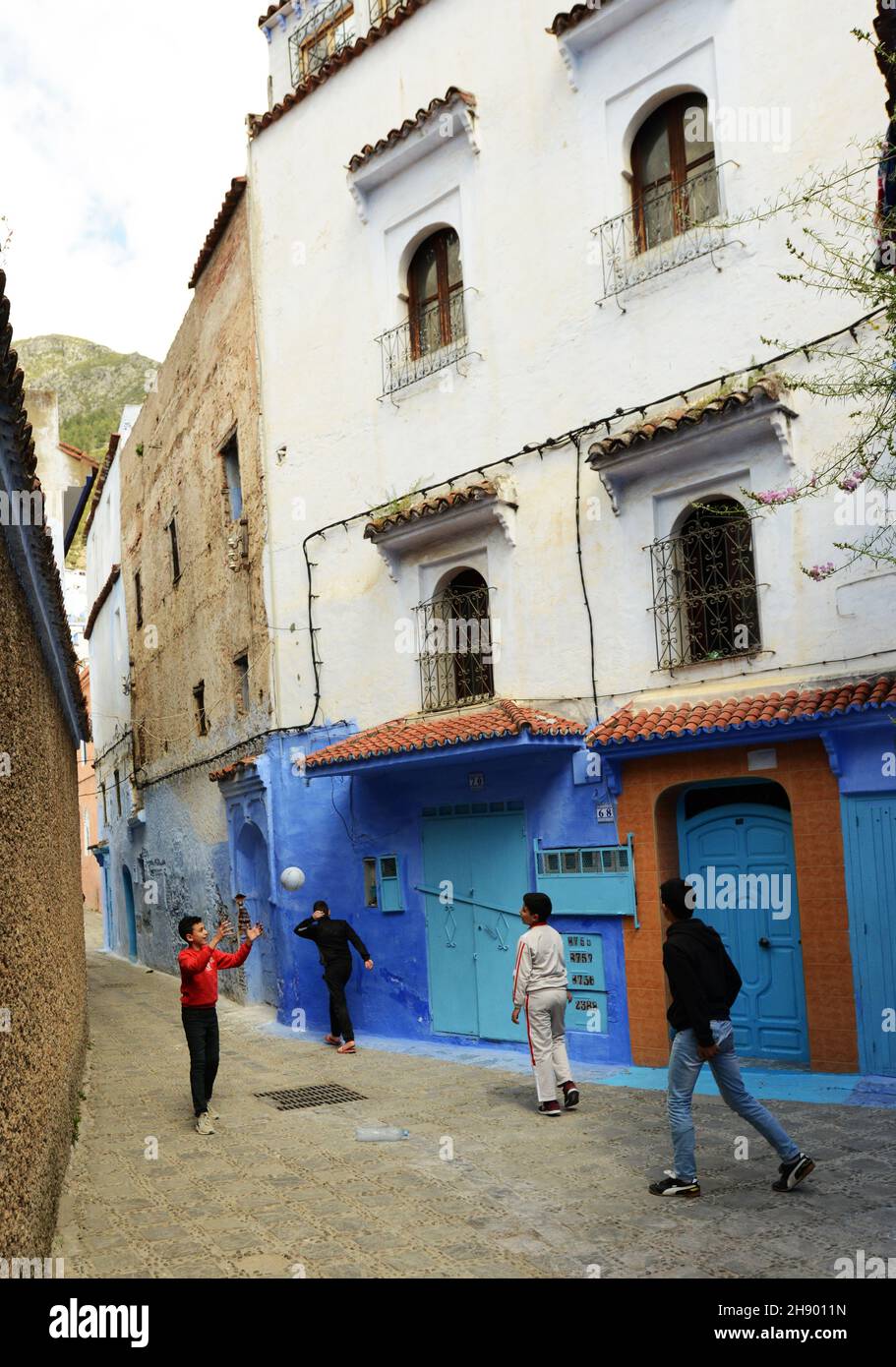 Ragazzi marocchini che giocano a calcio tra le case tradizionalmente ...