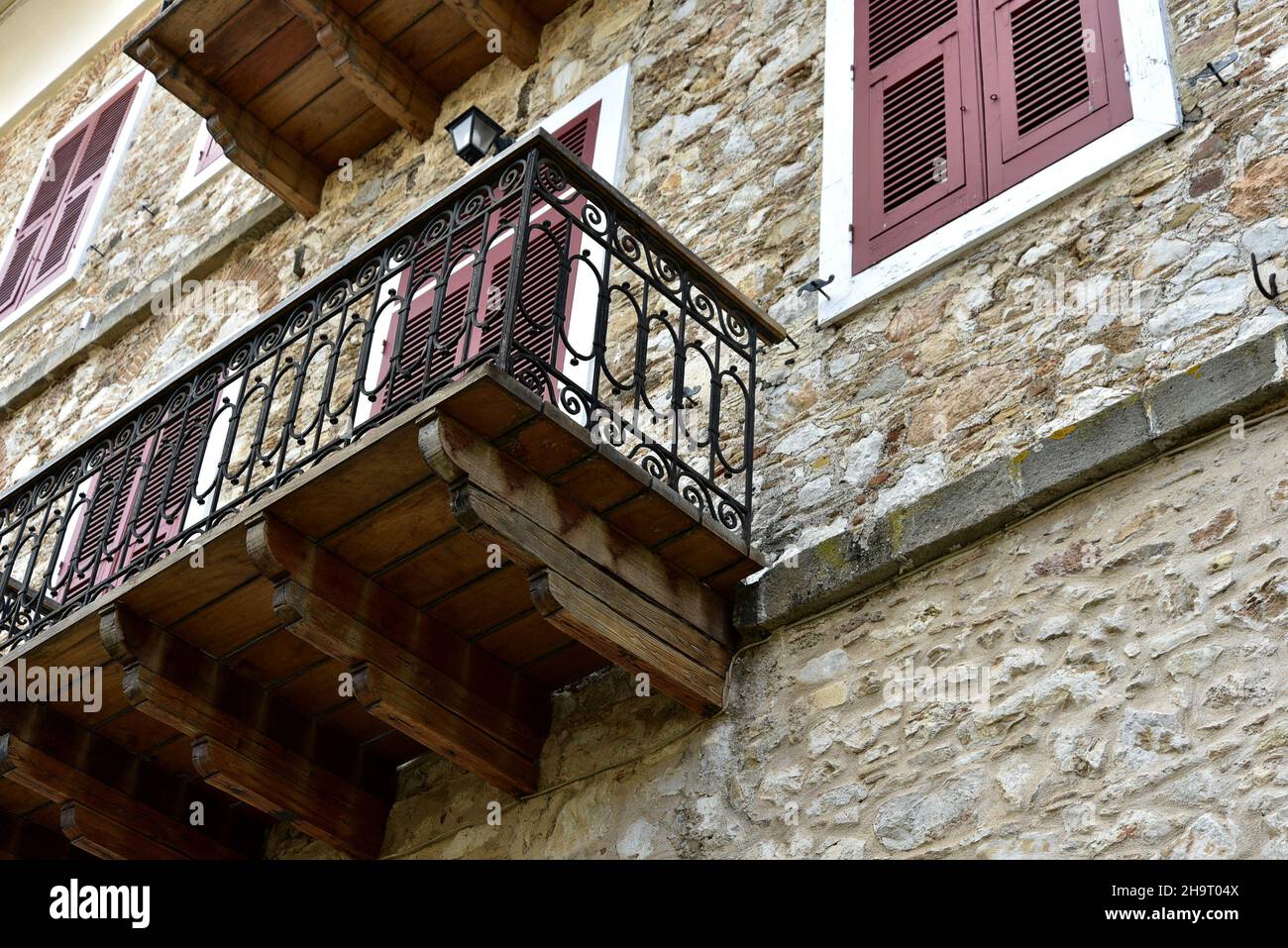 Antica facciata tradizionale rurale con un muro in pietra, persiane ...