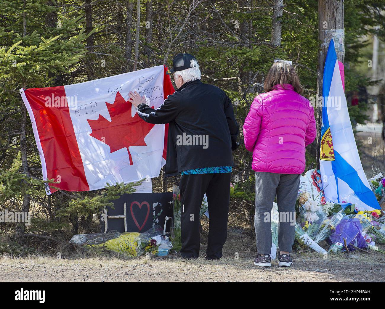 Un paio di piazzano una bandiera in un memoriale a Portapique, N.S ...