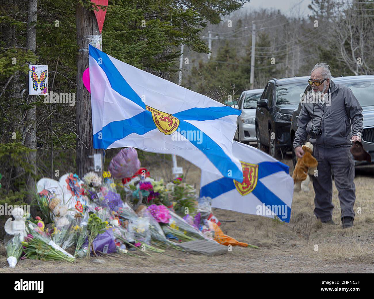 Un uomo paga i suoi rispetti ad un memoriale stradale a Portafique, N.S ...