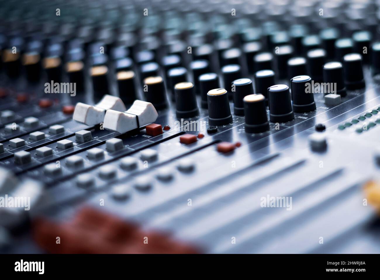 Tecnico del suono che utilizza la console di missaggio per produrre una ...