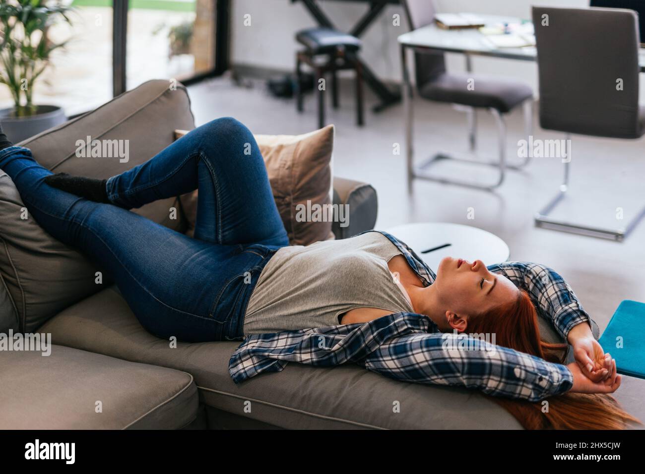 Giovane donna distesa sul divano Foto stock - Alamy