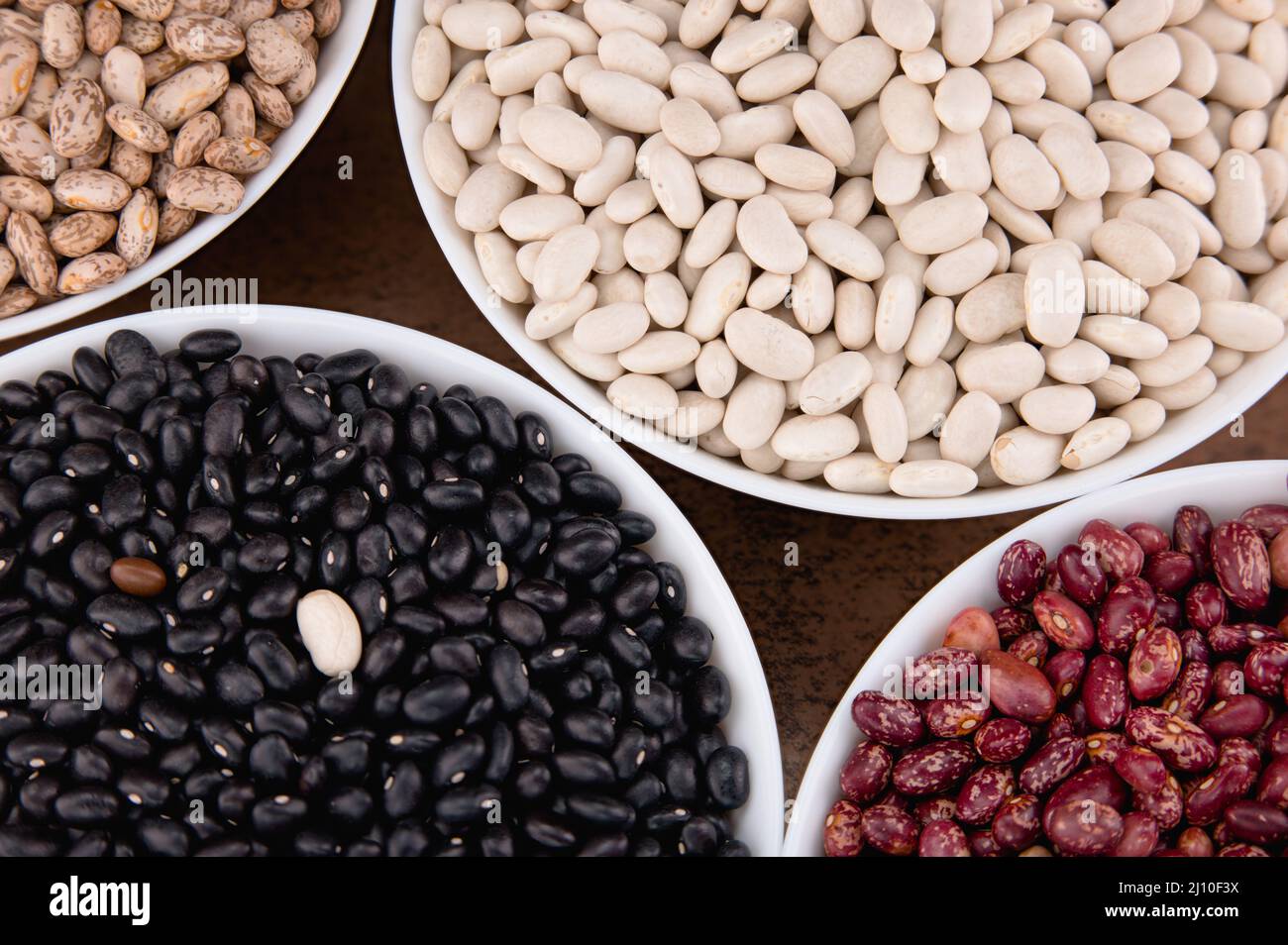 La foto mostra fagioli rossi, bianchi e neri. La consistenza dei semi è ...