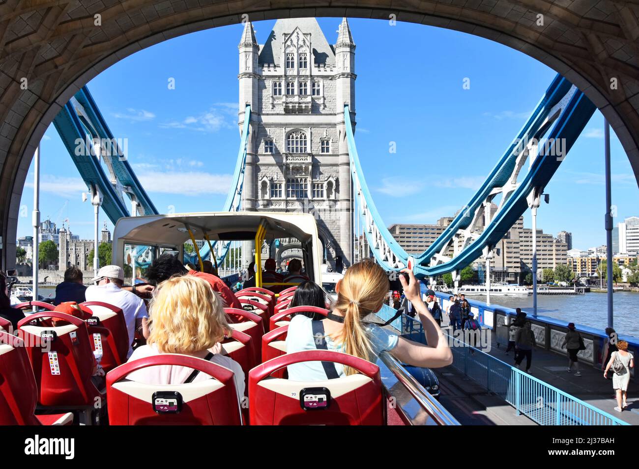 Back view women on double decker open top London tour bus sotto l'arco ...