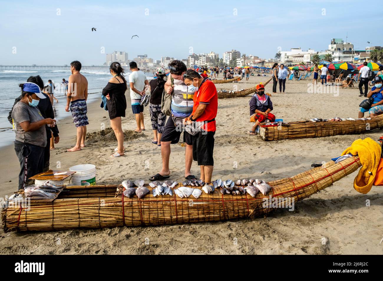 Gente del posto che vende pesce fresco dai loro Caballitos De Totora ...