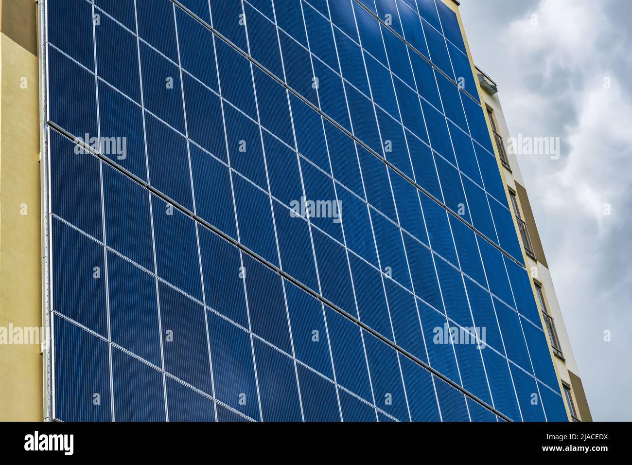 pannelli solari sul muro di un edificio a più piani su sfondo di nuvole ...