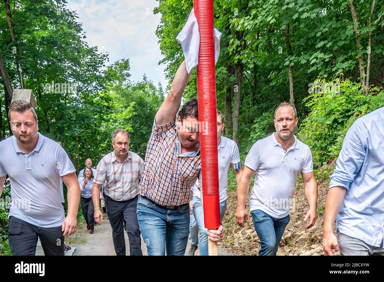 05 giugno 2022, Baviera, Bogen: I pellegrini trasportano un tronco di ...