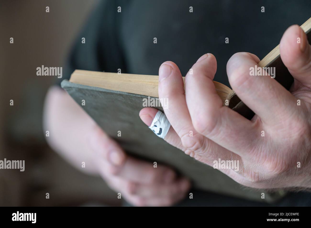 Un uomo sta leggendo un libro mentre lo tiene nelle sue mani. La prima ...