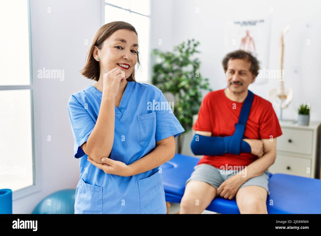 Donna medico di mezza età con paziente con lesione al braccio alla ...