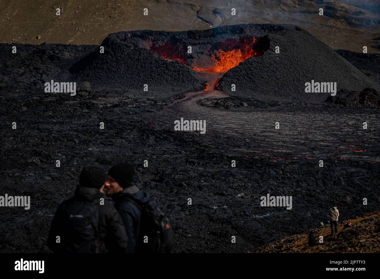 I turisti visitano un cratere a forma di cuore mentre la lava scorre ...