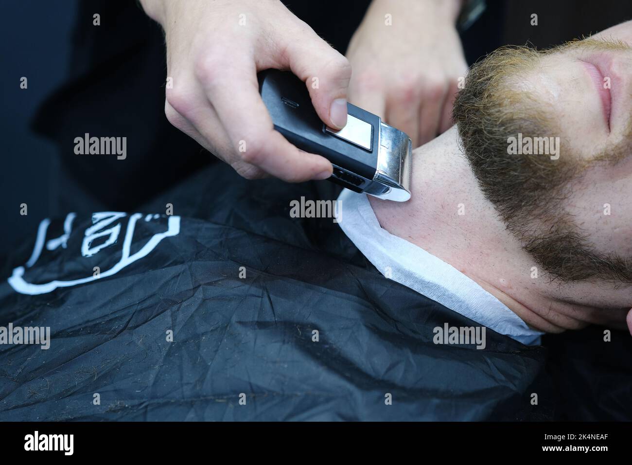 Il barbiere Professional Master rasa la barba del cliente con un ...