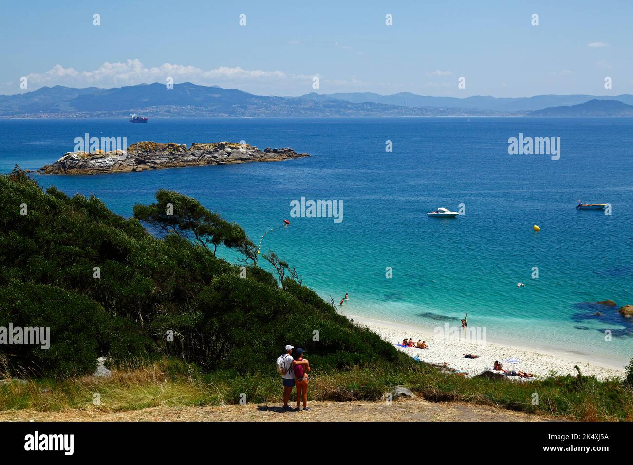 Turisti che guardano la vista sulla spiaggia di Playa de Nuestra Señora ...