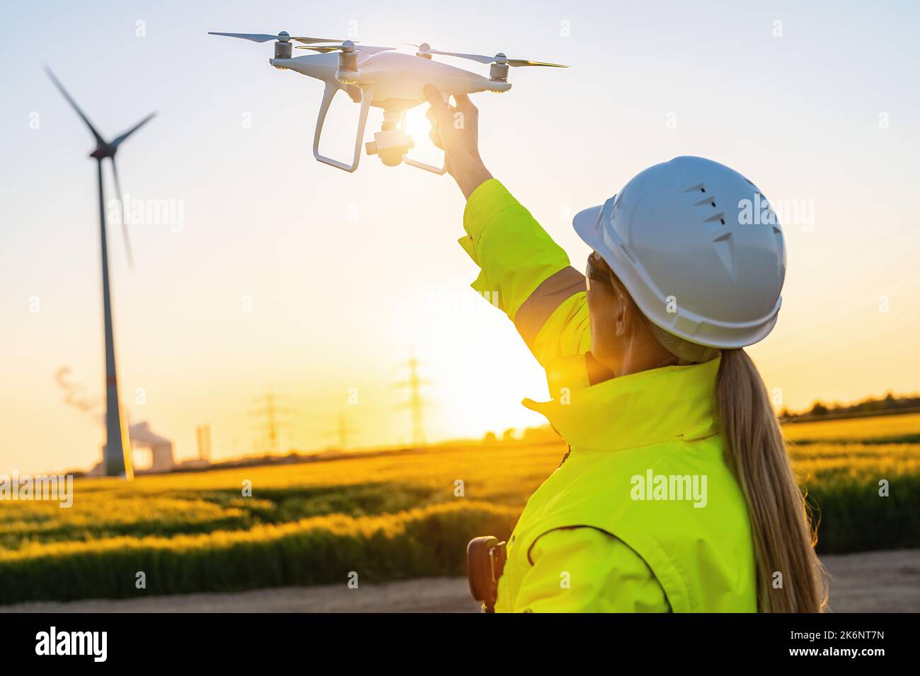 Operatore femminile che tiene il drone per ispezionare la turbina ...
