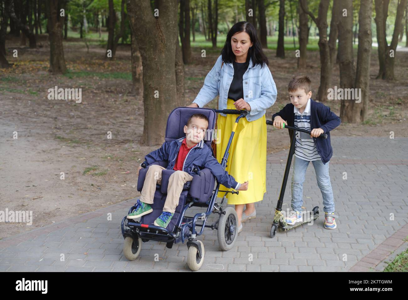 Famiglia con bambino che ha paralisi cerebrale, utente su sedia a ...
