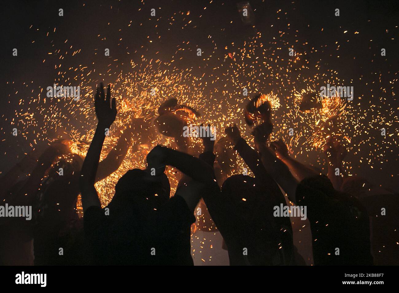 I giovani balinesi che picchiano le conchiglie di cocco bruciate e ...