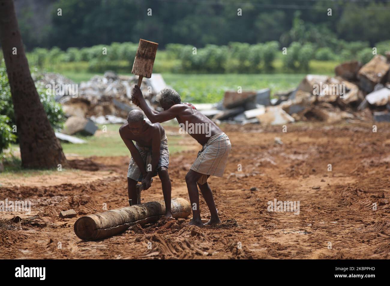 Gli operai usano un'ascia con uno scalpello, un cuneo e un mazzuolo di ...